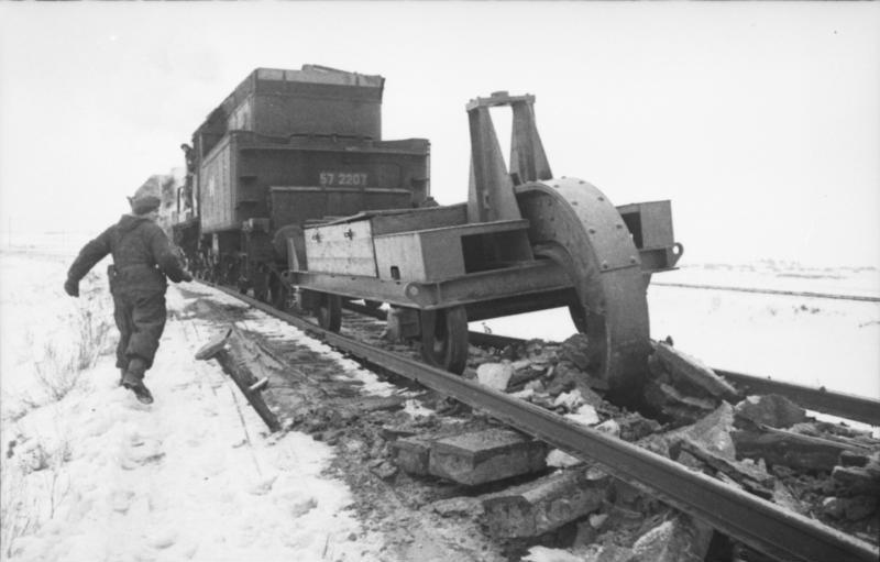German troops use a Schwellenpflug to destroy rail tracks while ...